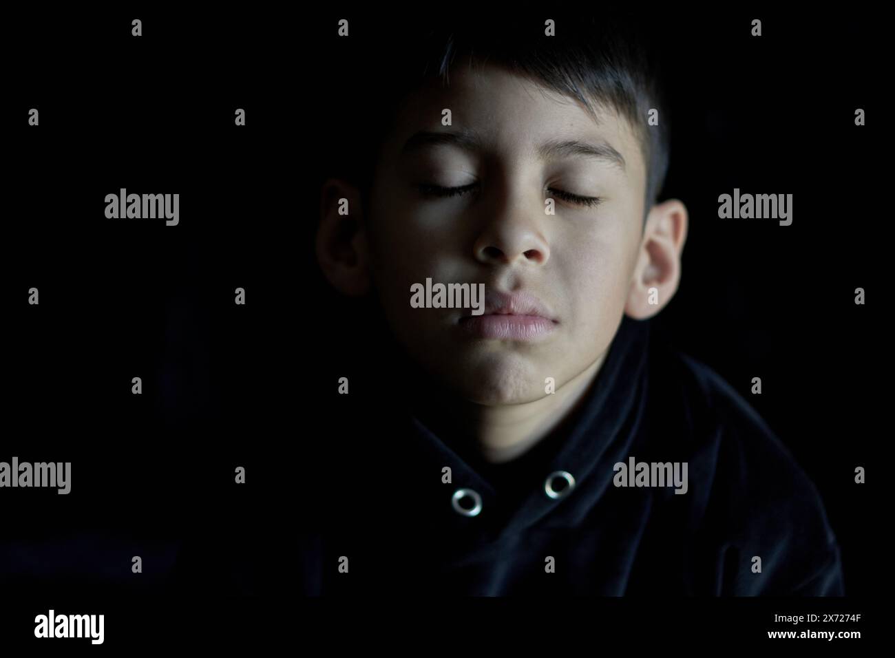 close-up portrait of latin child's face with closed eyes with sadness ...