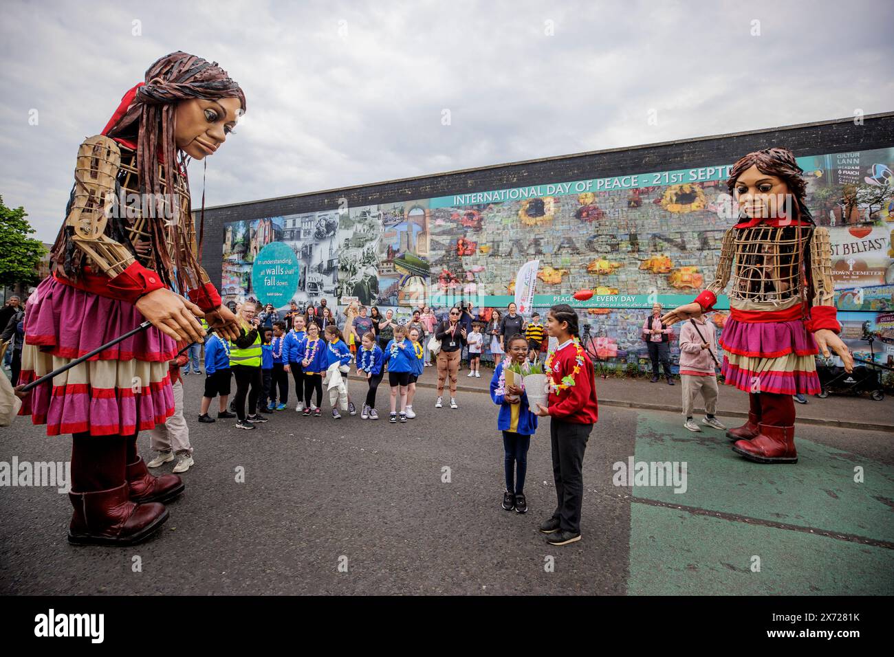 Local school children look at Little Amal, a 12-foot tall puppet of a ...