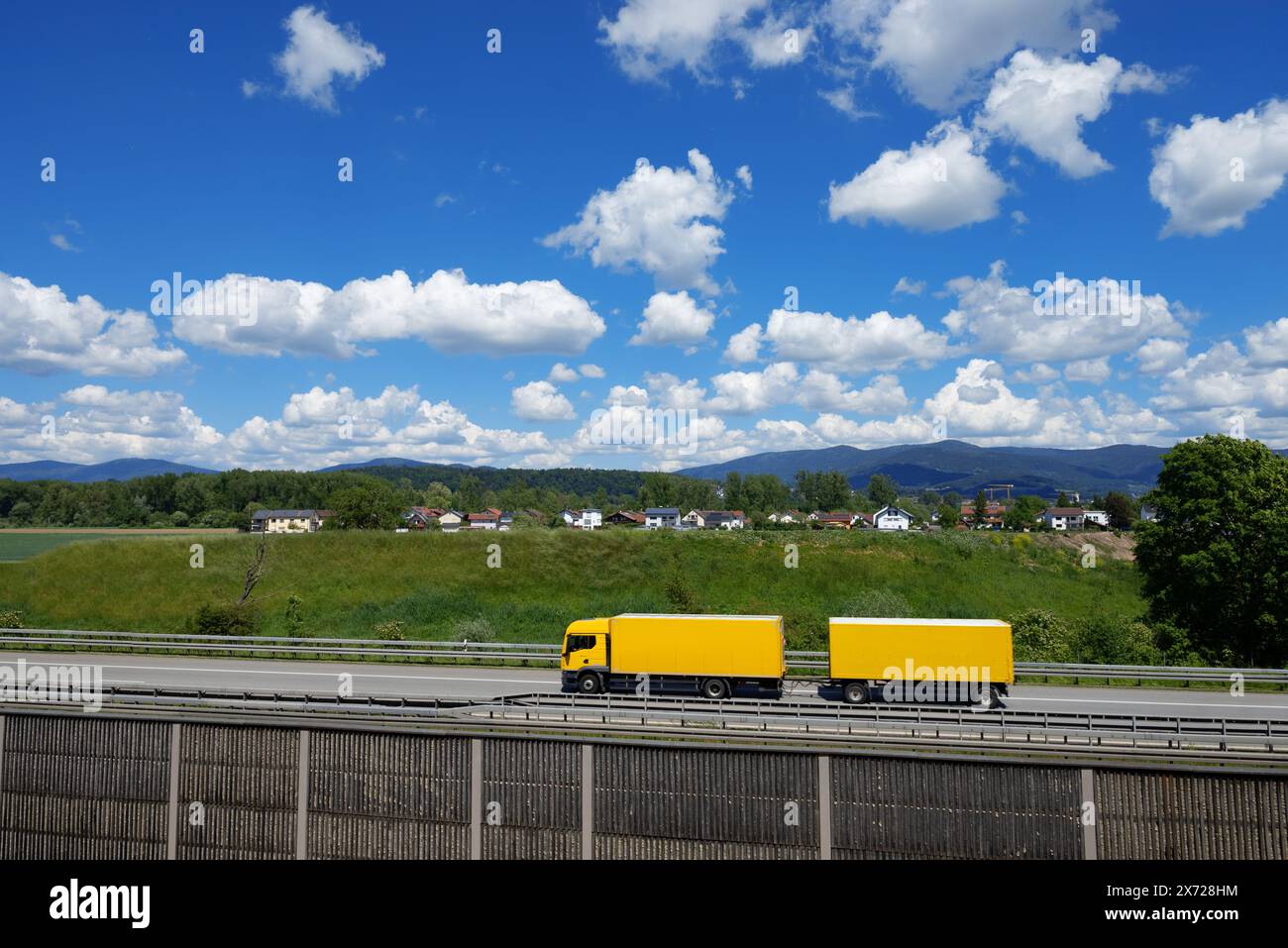 yellow lorry with trailer passes Deggendorf on the A3 motorway ...