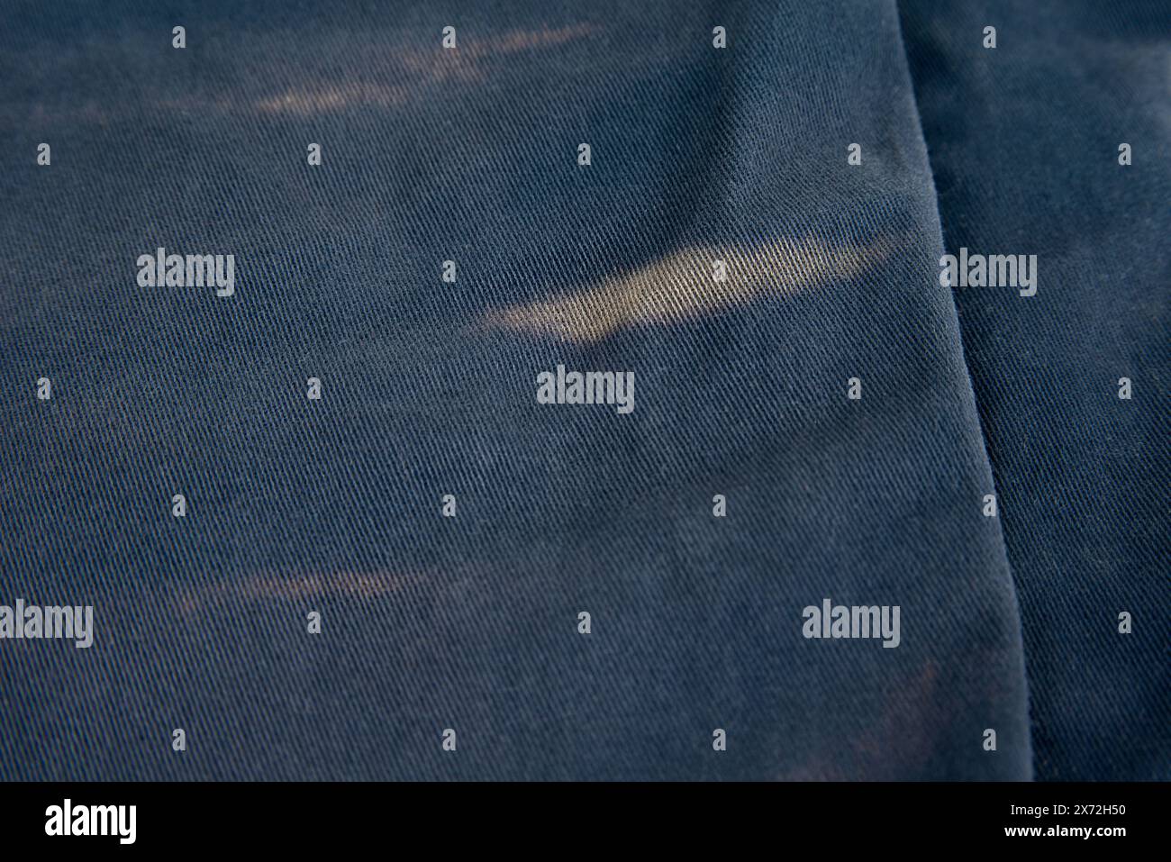 Sweat stains on colored pants on knees. Fade out color Stock Photo - Alamy