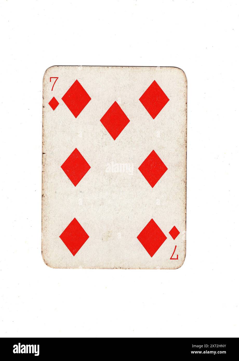 An antique seven of diamonds playing card isolated on a white ...