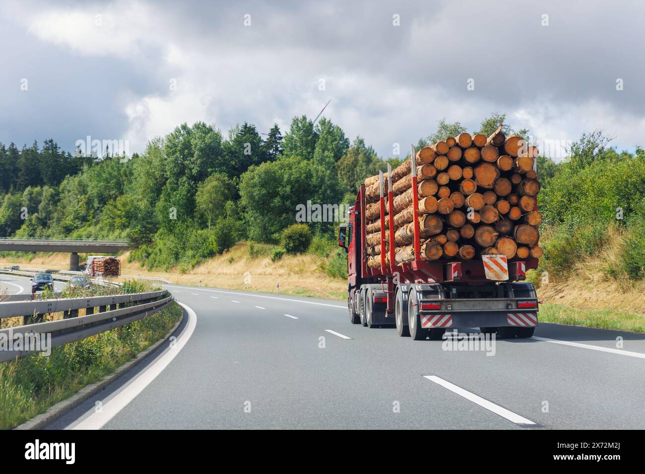 Back view many long heavy industrial wood carrier cargo vessel truck ...