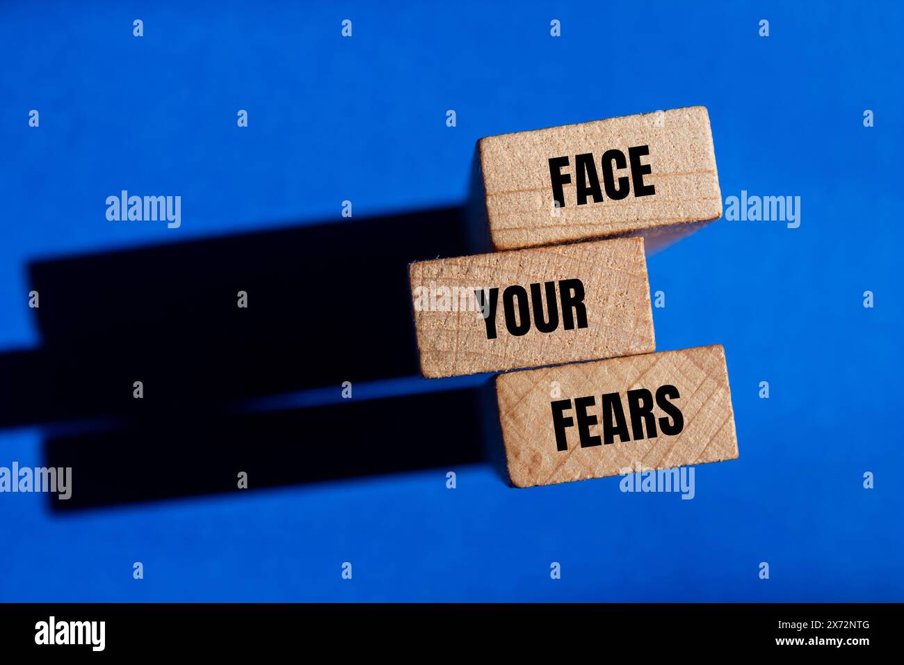 Face your fears words written on wooden blocks with blue background ...