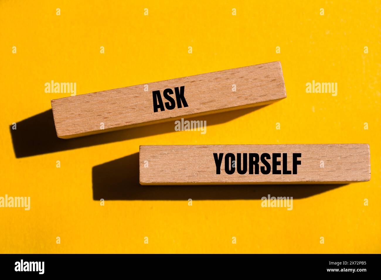 Ask yourself words written on wooden blocks with yellow background ...