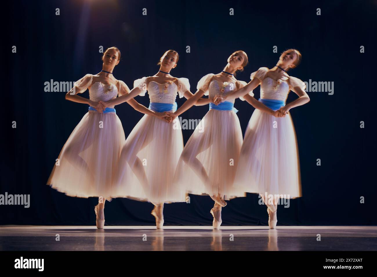 Charming young girls, ballet dancers in white tutus with blue bows on ...