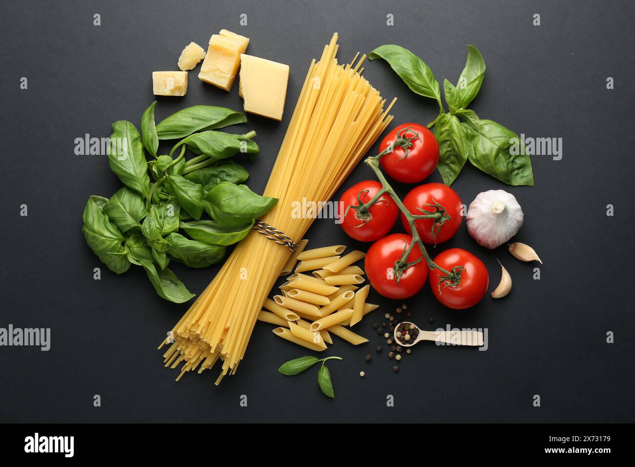 Different types of pasta, spices and products on black background, flat ...