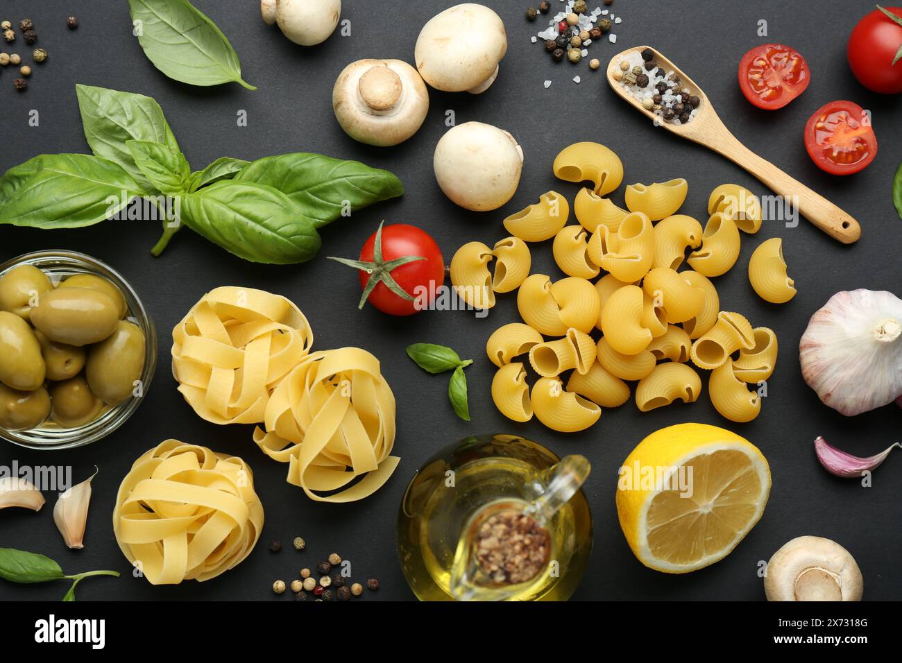 Different types of pasta, spices and products on black background, flat ...