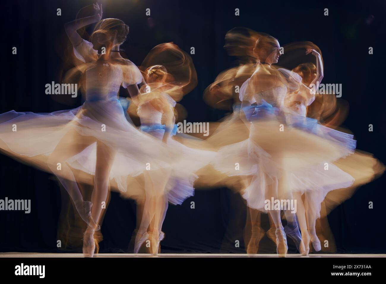 Young ballet ensemble in sheer dresses creating illusion of multiple ...
