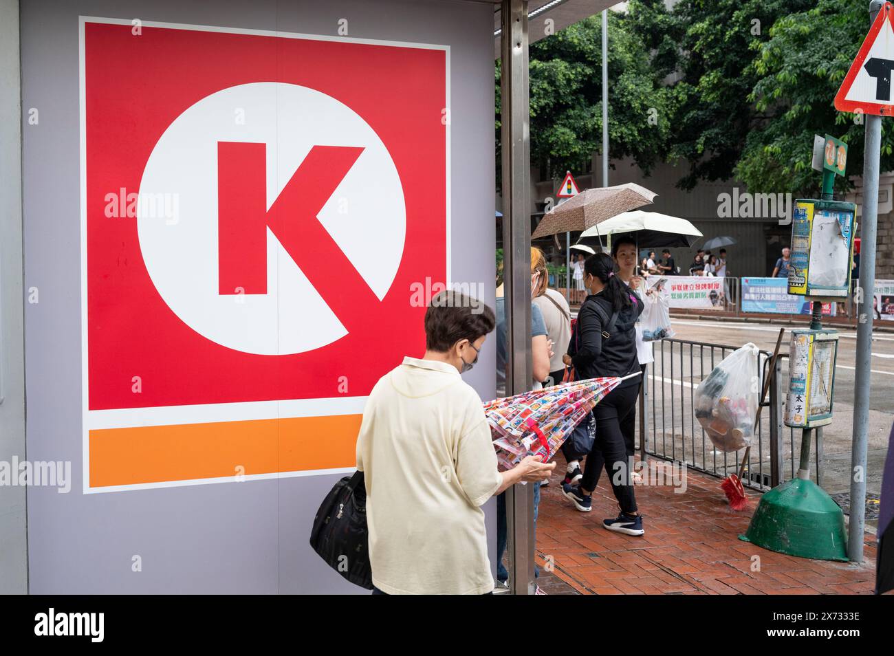 Pedestrians walk past the Canadian-owned American multinational chain of convenience store ...