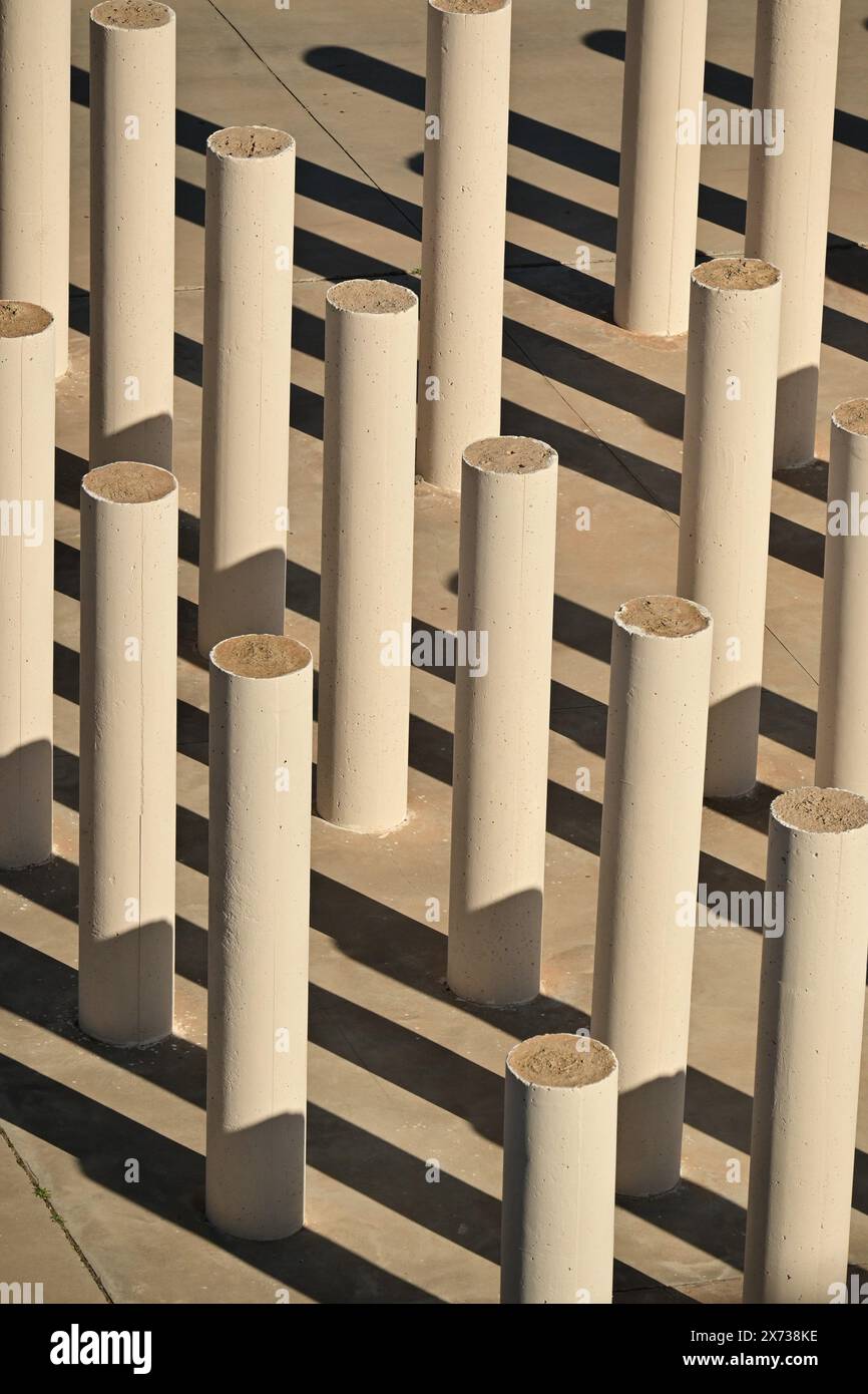 Aerial view of cylindrical concrete pillars casting long shadows on a ...