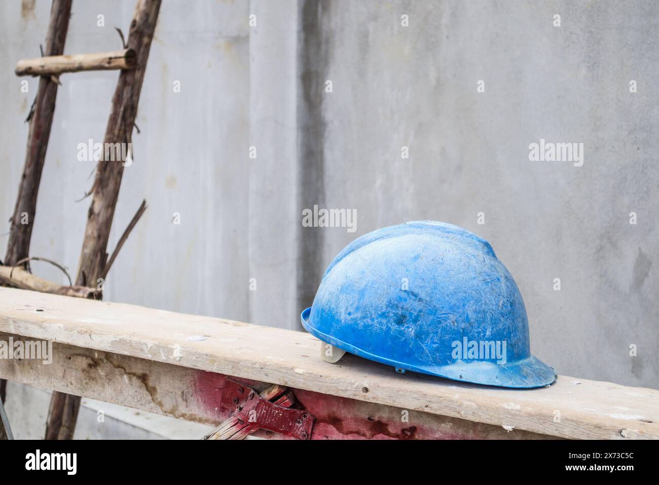 Blue hard hat on house building construction site Stock Photo - Alamy
