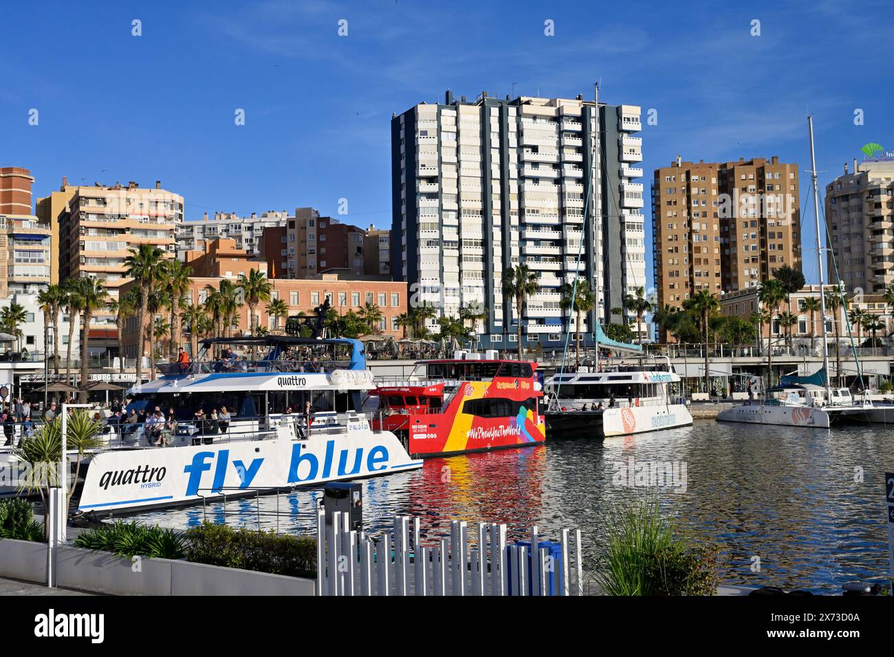Malaga marina and waterfront with “Fly Blue” and other tourist ...