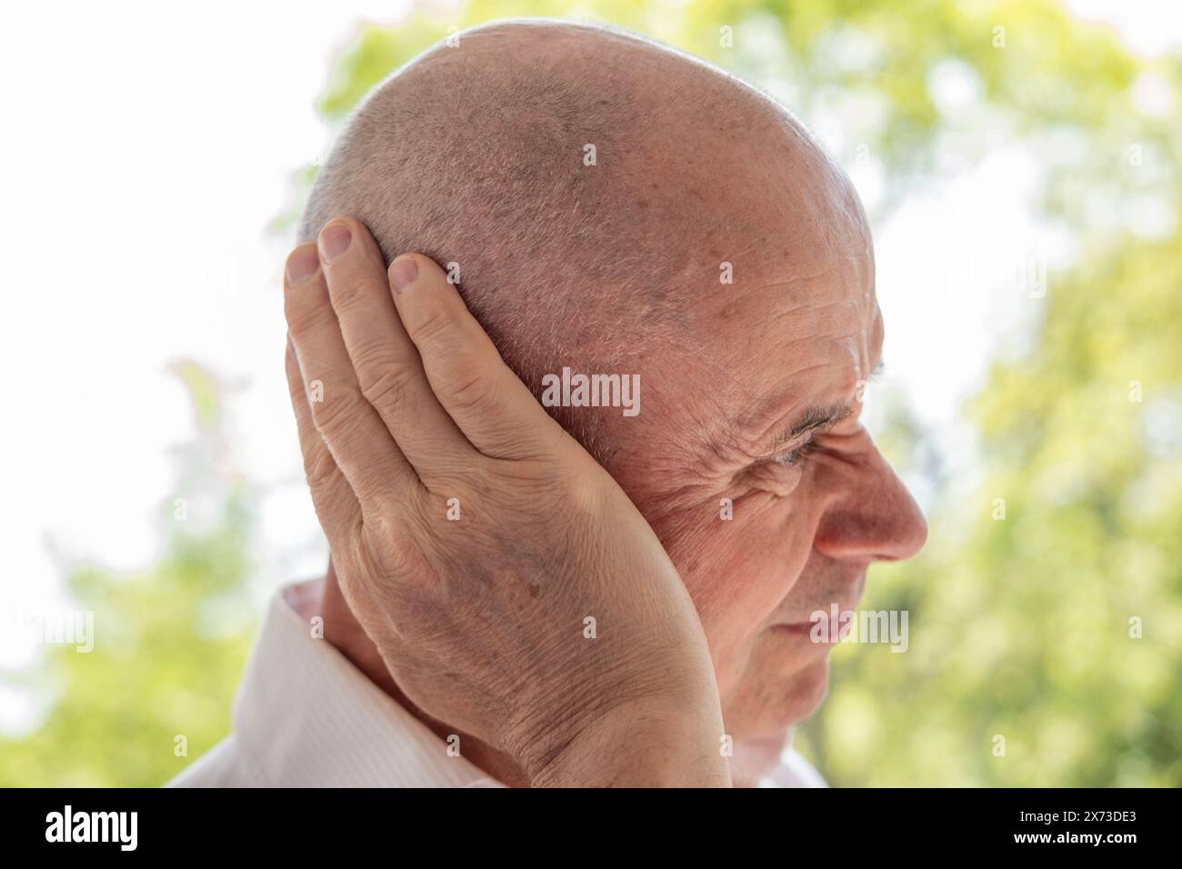 mature man holds painful ear, hearing loss, face close-up, medical ...