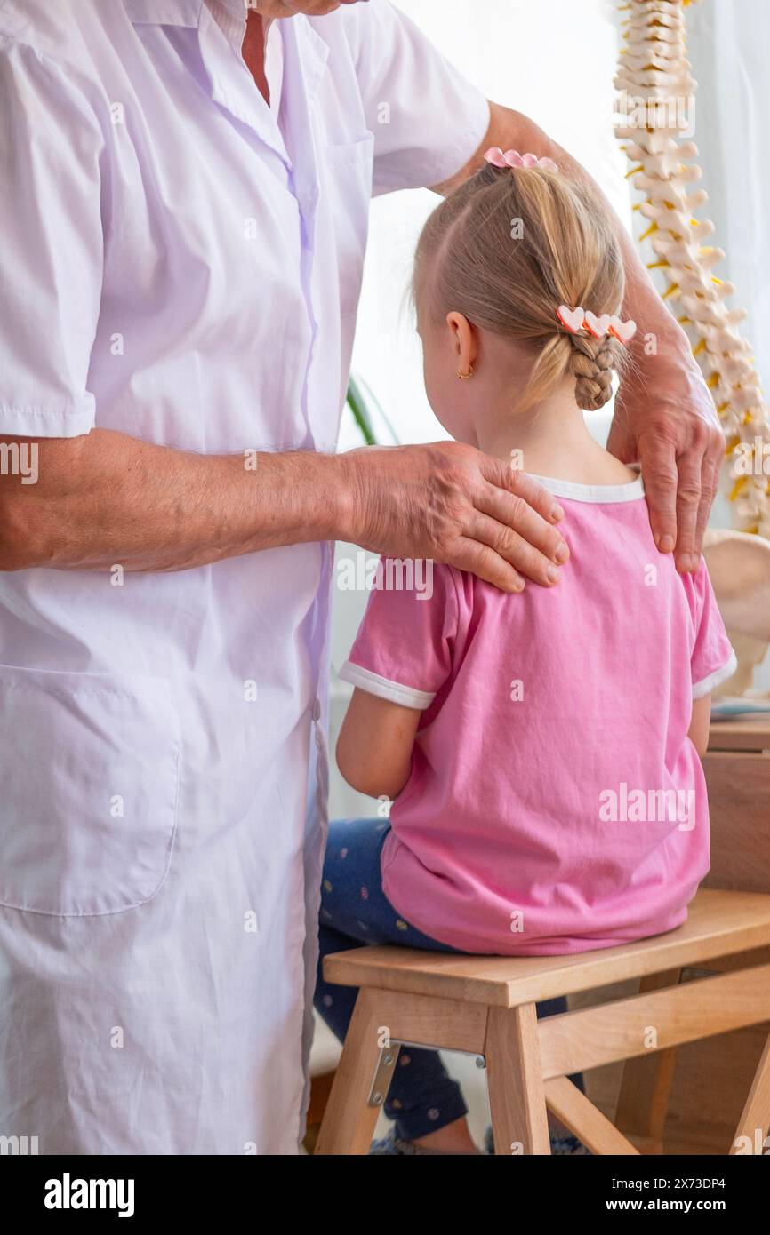 male Orthopedist doctor examining child's back in clinic, physician ...