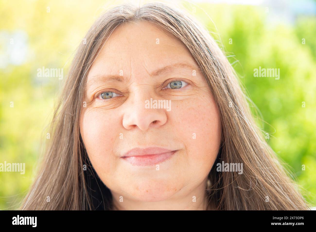 Caucasian positive 50-year-old attractive woman with long hair poses ...