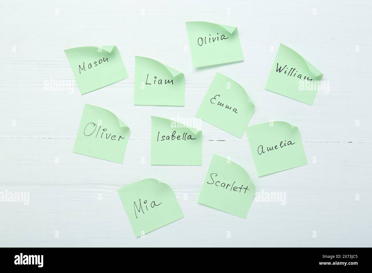 Paper stickers with different names on white wooden background, flat ...