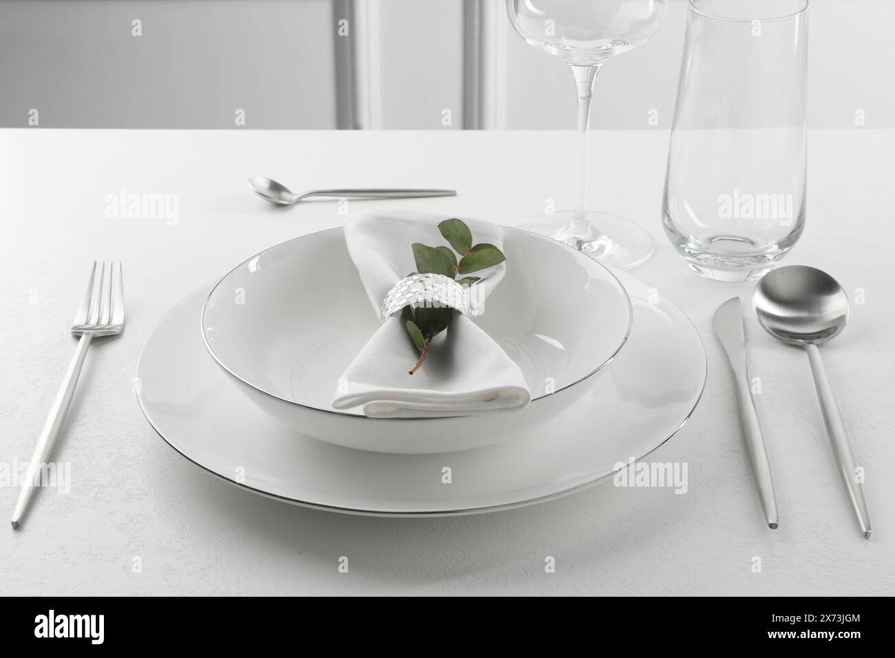 Stylish setting with cutlery and napkin on white textured table Stock ...