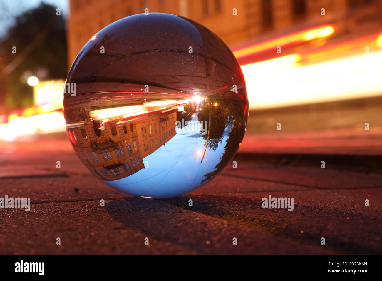 Beautiful city street, overturned reflection. Crystal ball on asphalt ...