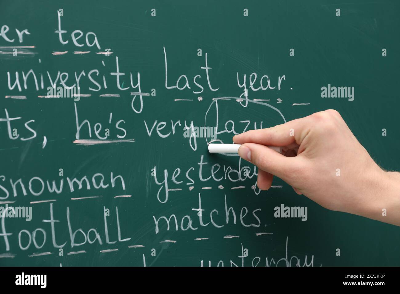 English teacher writing with chalk on green chalkboard, closeup Stock ...