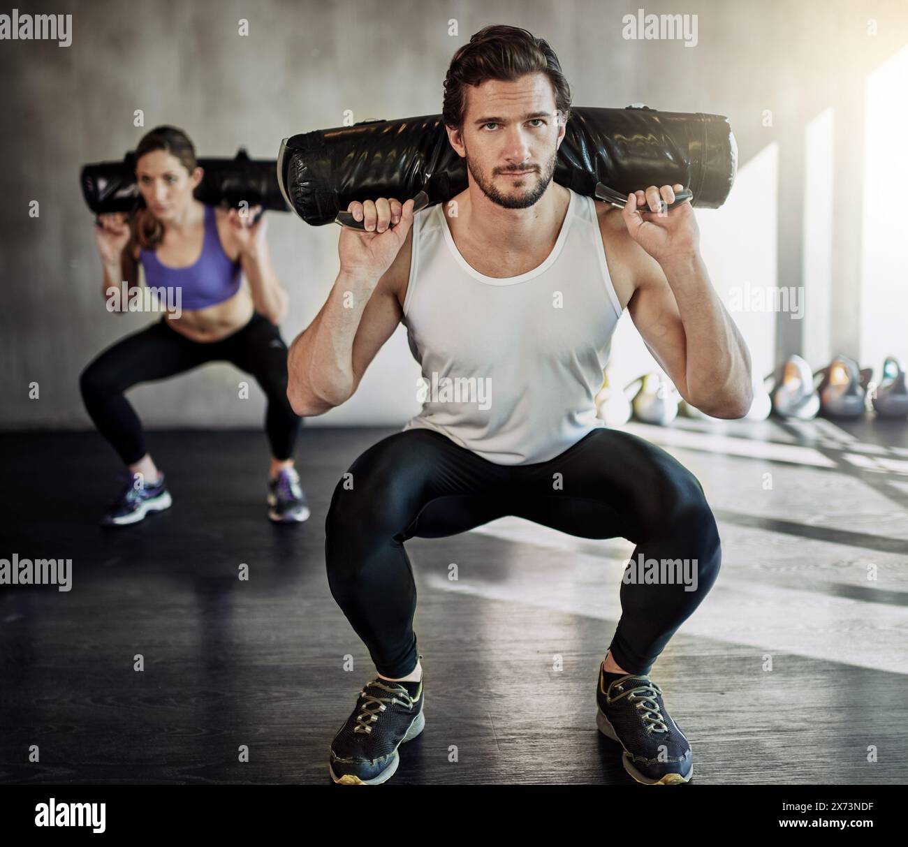 People, squat and sandbag exercise for gym training or weightlifting ...