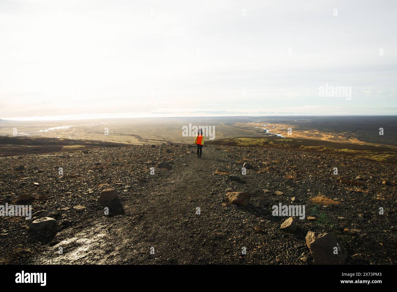 Majestic scenery of Icelandic viewpoint with female hiker walking ...