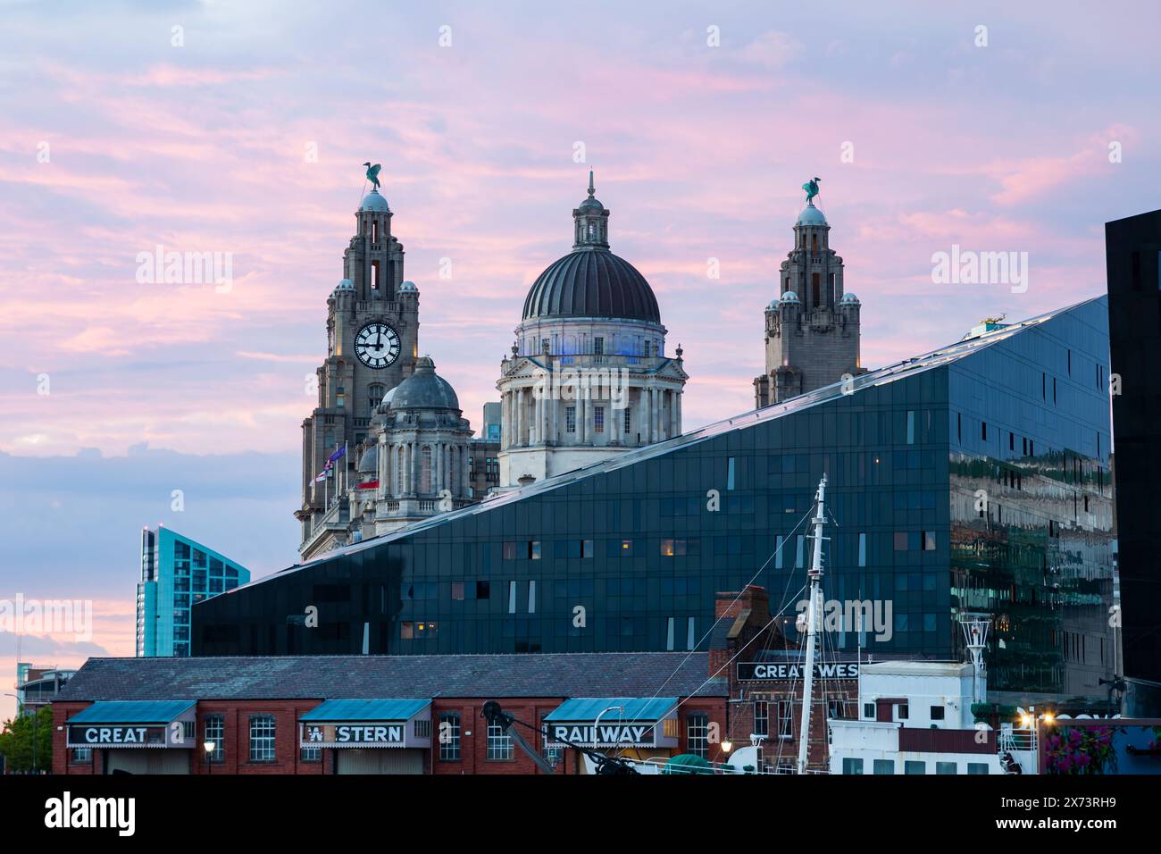 Liverpool waterfront at sunset. The Three Graces dominate the skyline ...