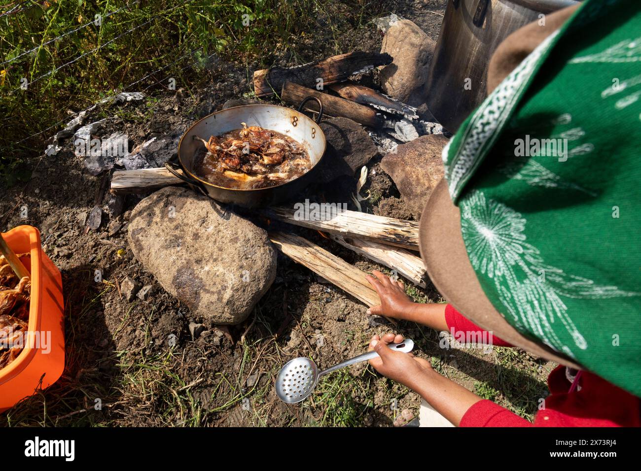 Indigenous woman cooking over firewood with metal pots and frying pan ...