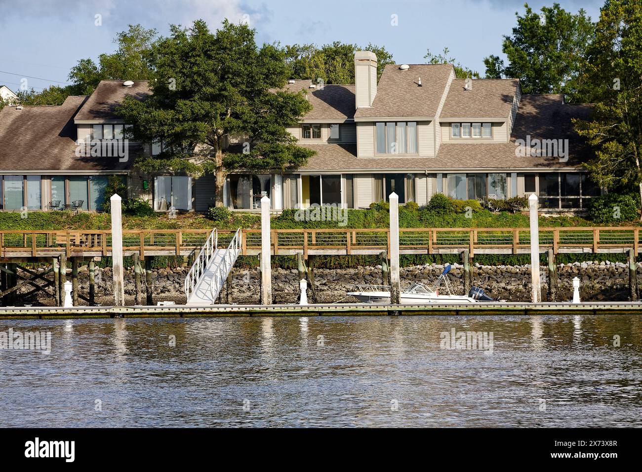 large house, on water, long dock, long floating dock, small boat, trees ...