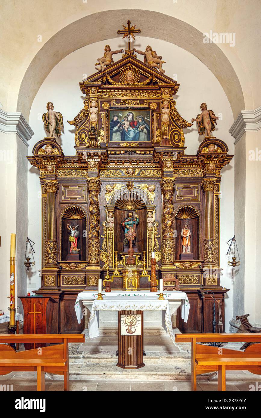 The Baroque-style altar, in carved and gilded wood with three statues ...