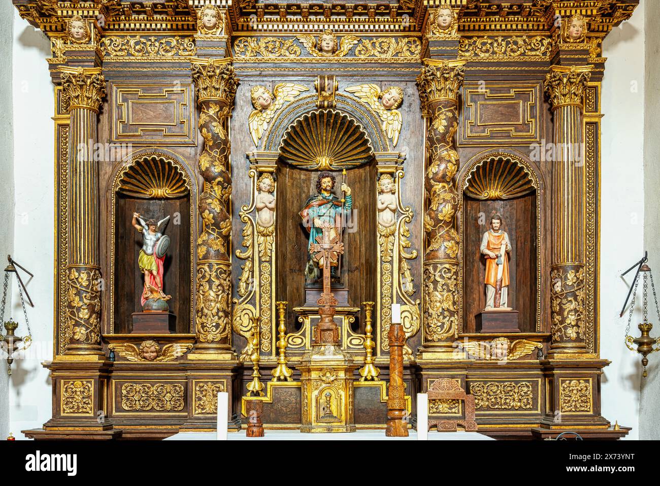 The Baroque-style altar, in carved and gilded wood with three statues ...