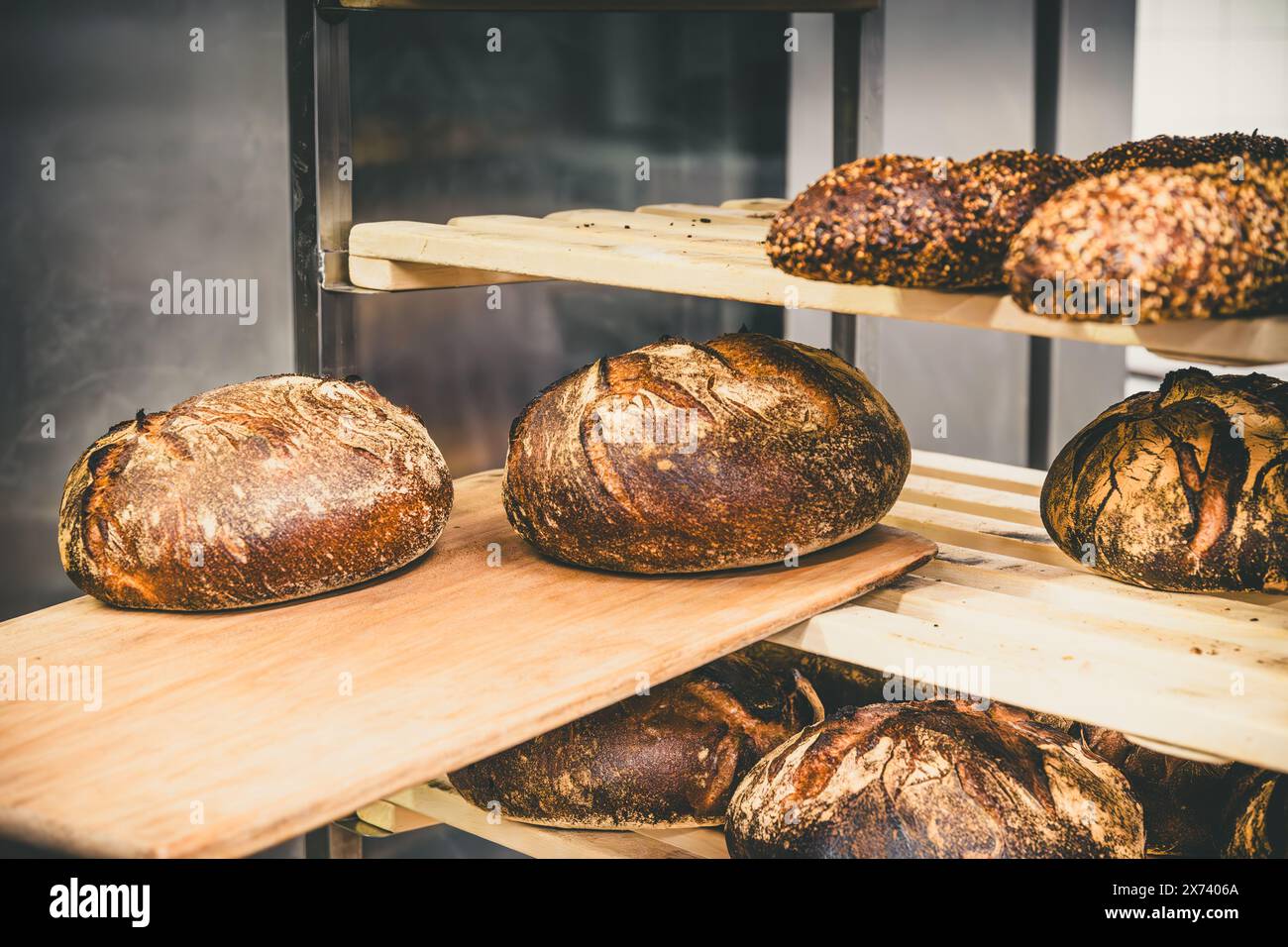 Freshly baked bread is pushed into a wooden shelf cart in a bakery ...