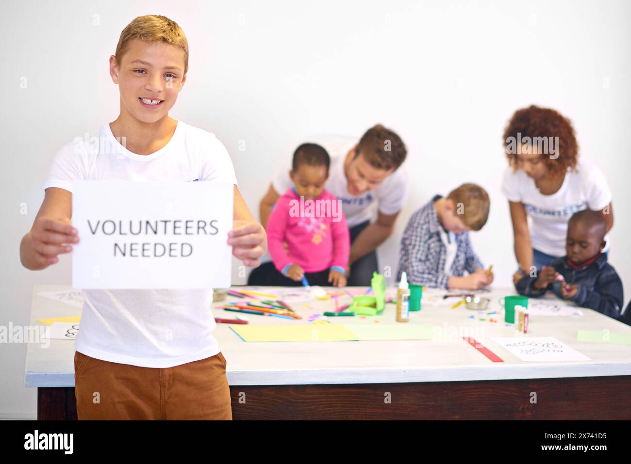 Volunteers needed, portrait and child with sign in daycare for help ...