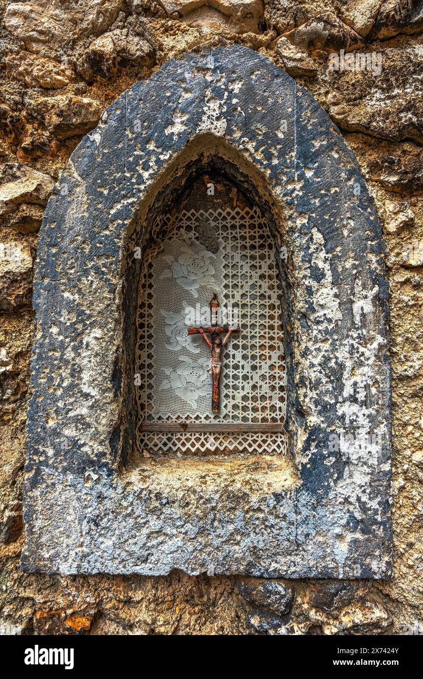 in a small ogival niche, a crucifix and a decoration of a fabric worked ...