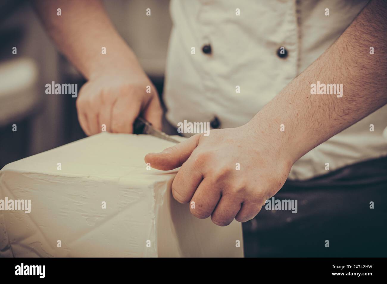 Baker cuts butter from a big block. Vintage style with grain Stock ...