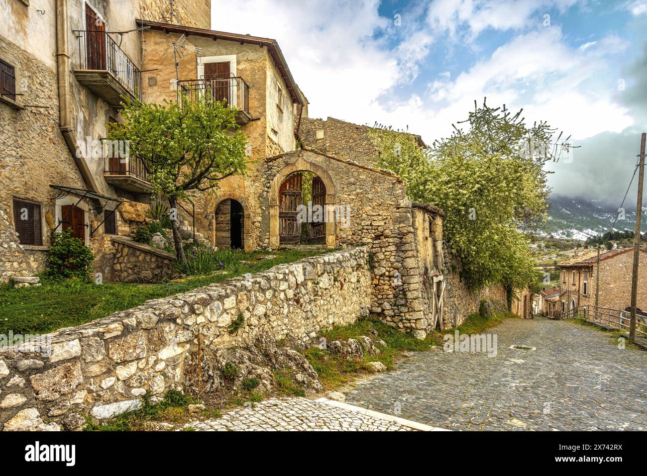 Glimpse of the stone buildings and the access gate to a courtyard of a ...