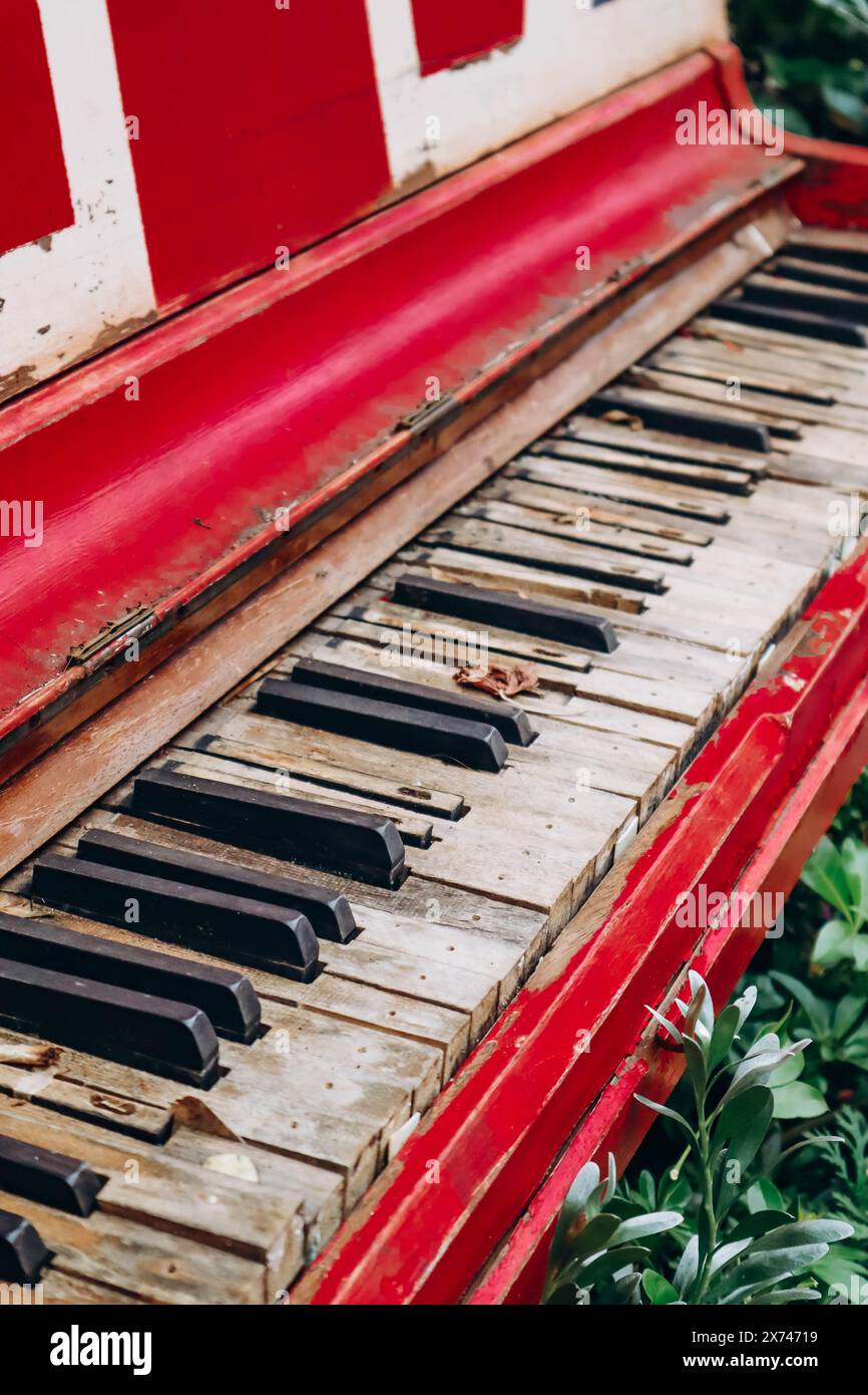 An old piano in the colors of the British flag with shabby keys on the ...