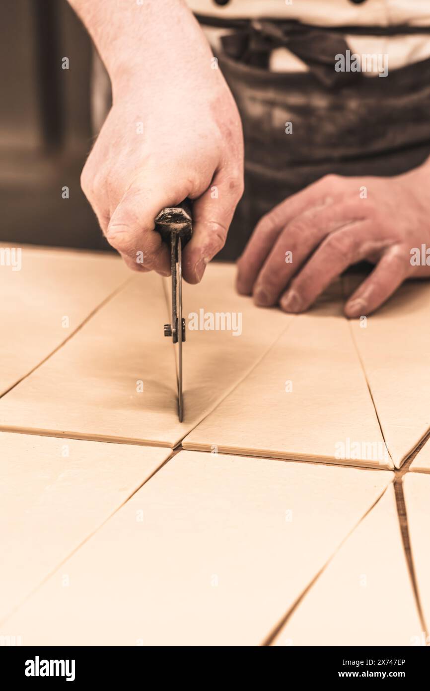Professional baker cuts dough with pastry cutter, vintage style with ...