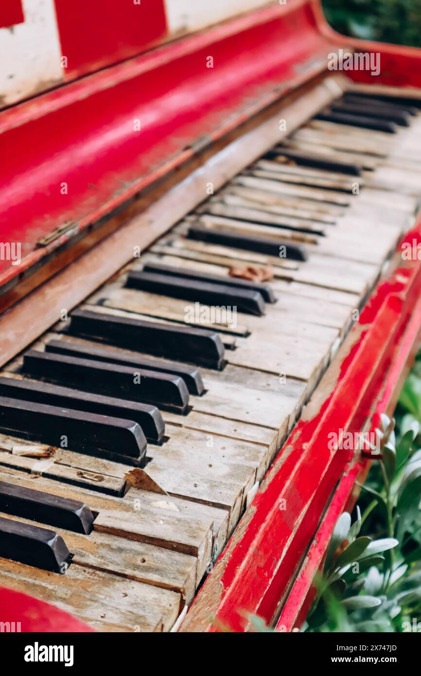 An old piano in the colors of the British flag with shabby keys on the ...