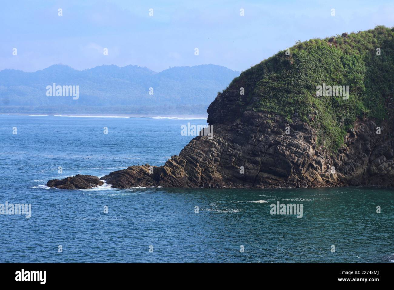 rocks on the edge of a coral island with calm sea waves Stock Photo - Alamy