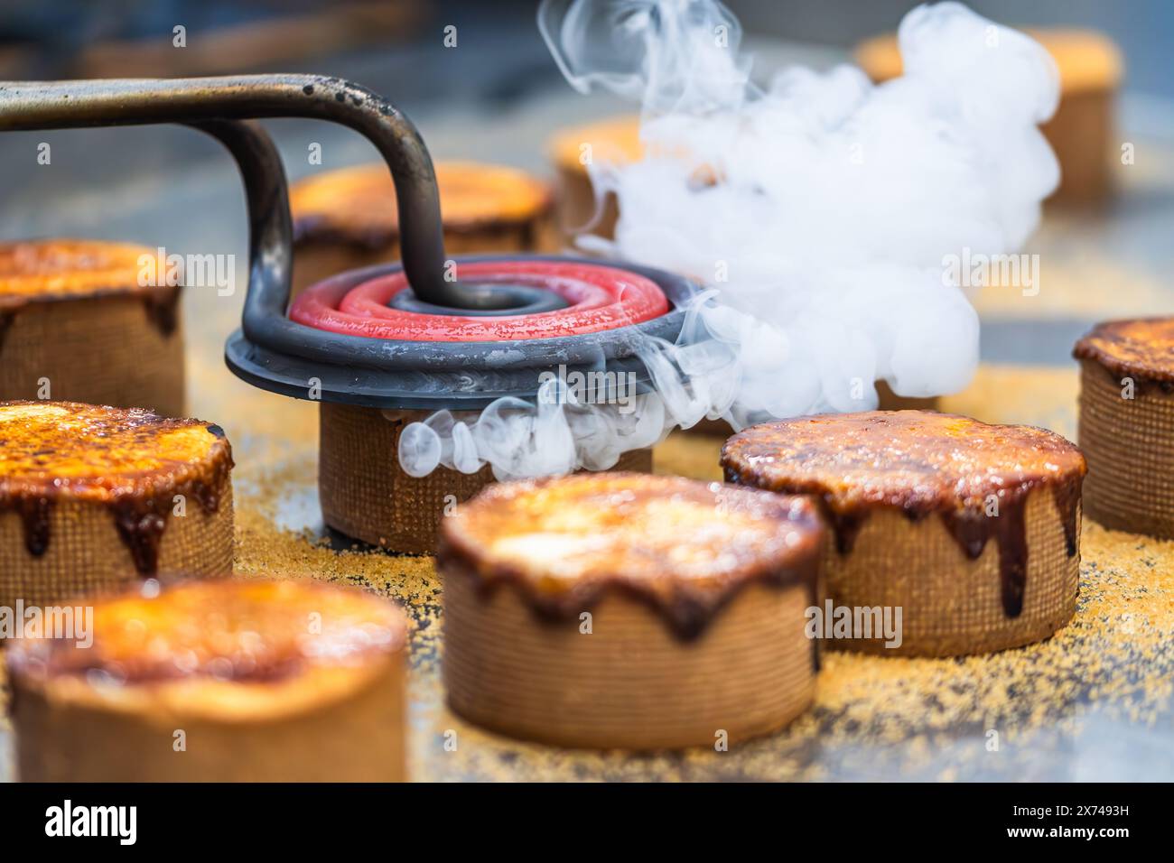 A tart is caramelized with a hot iron. Caramelization process Stock ...