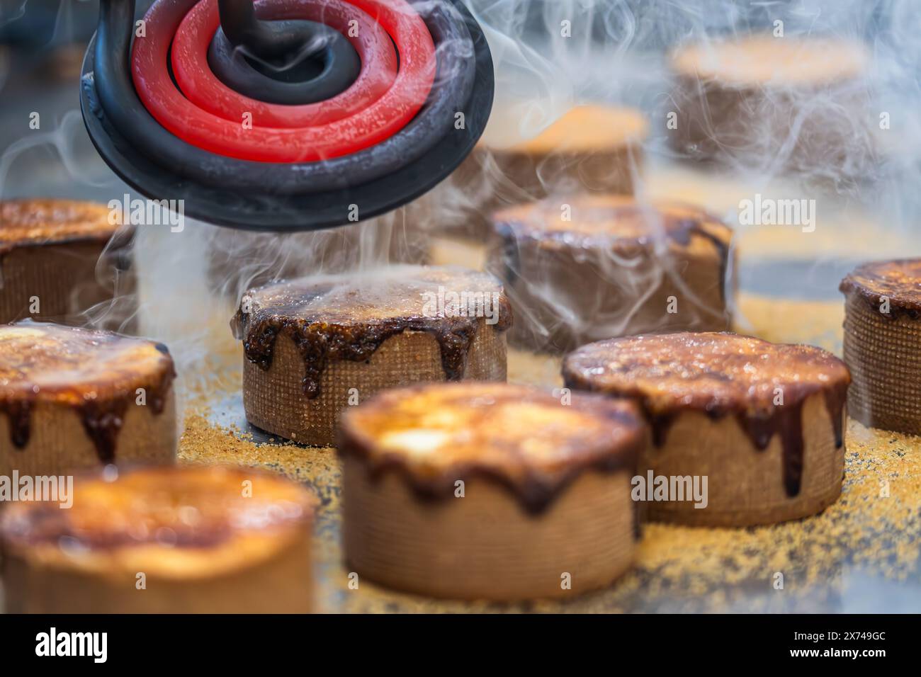 A tart is caramelized with a hot iron. Caramelization process Stock ...