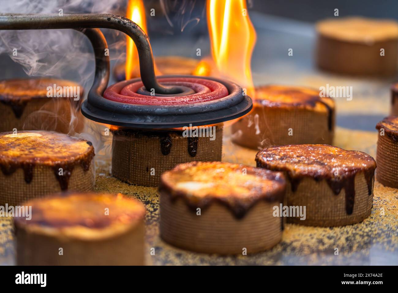 A tart is caramelized with a hot iron. Caramelization process Stock ...