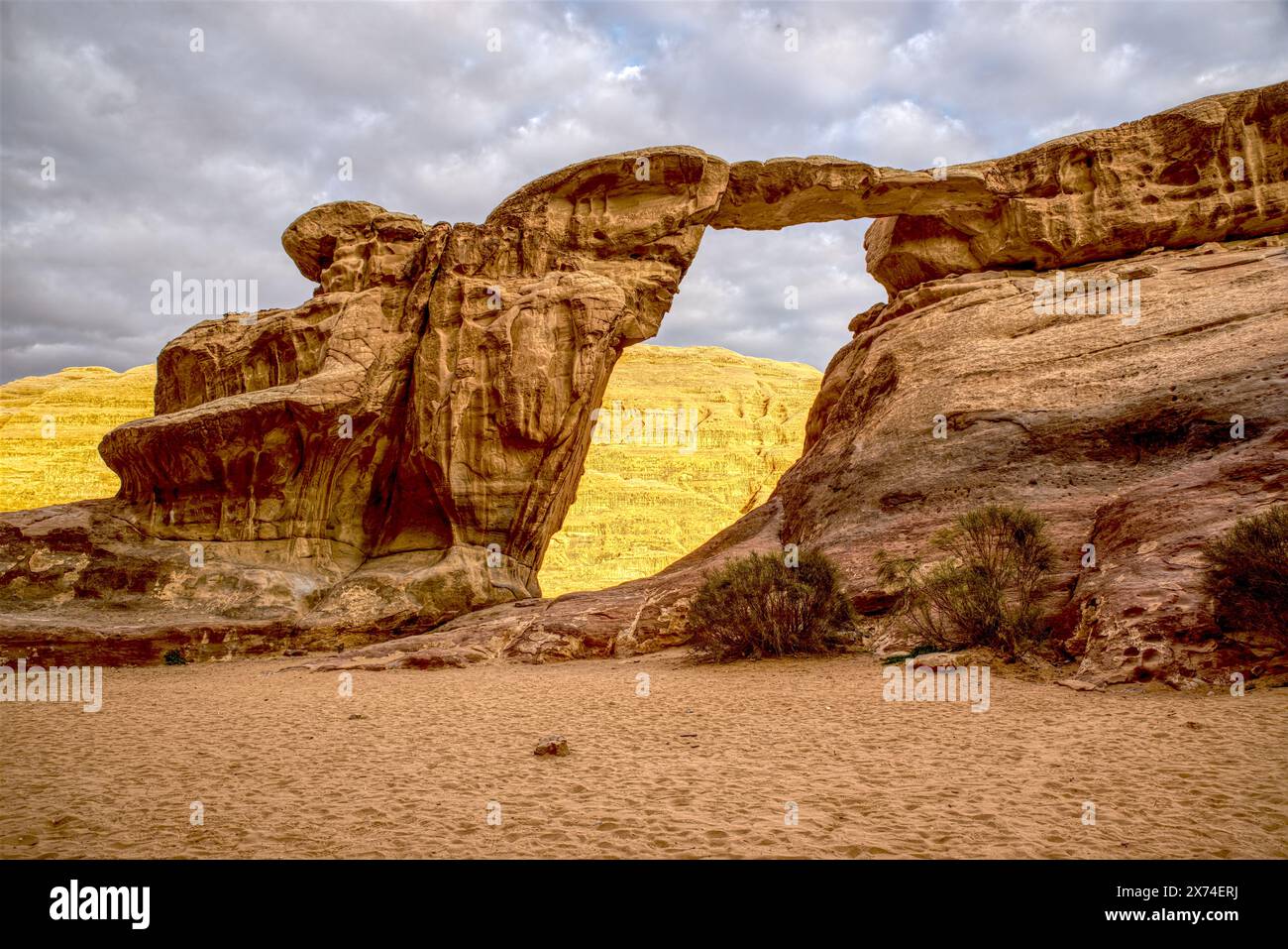 Wadi Rum Burdah Rock Bridge in Jordan with cloudy sky and golden ...