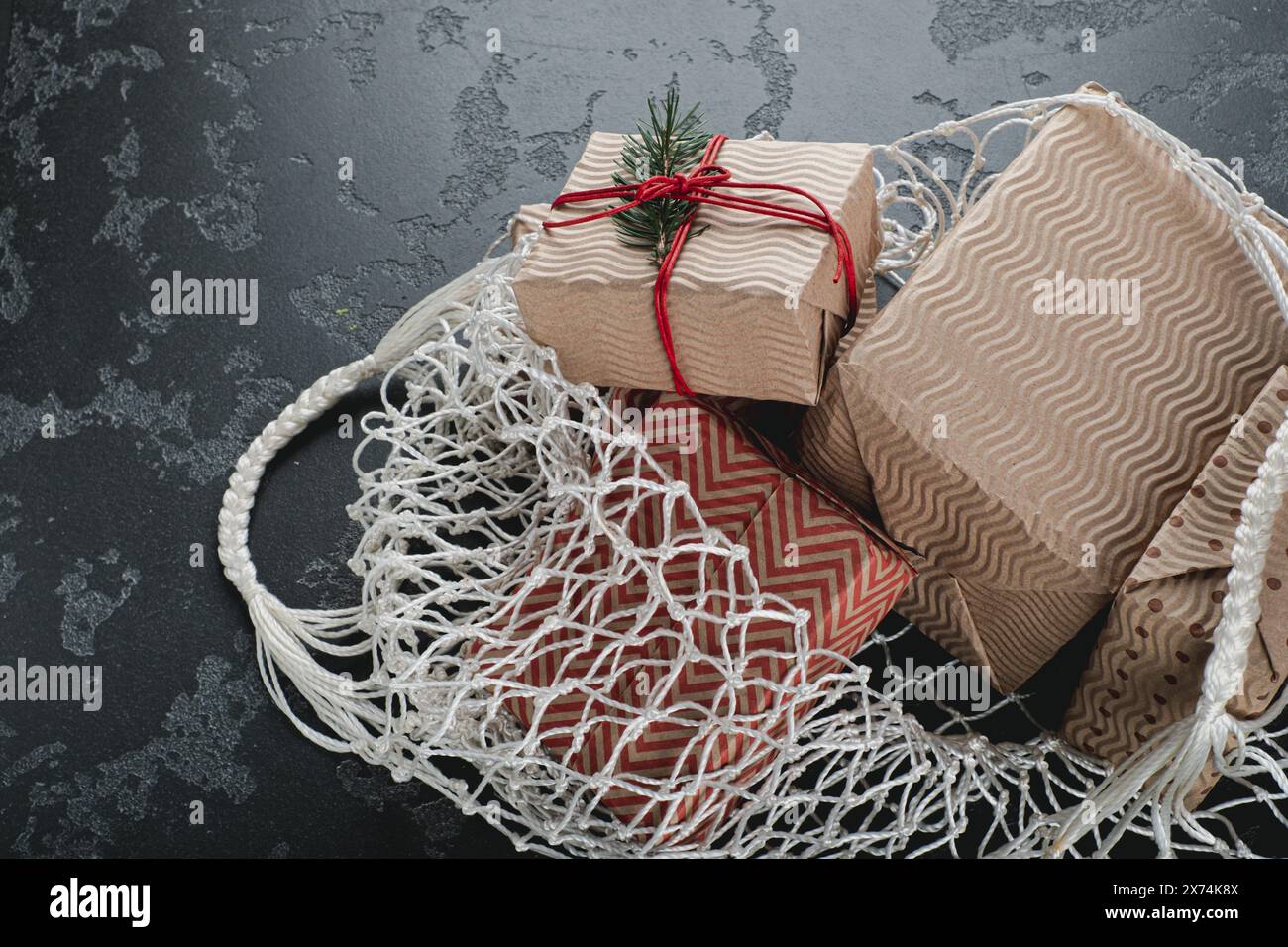 Reusable mesh bag with craft gift boxes on white background. Zero waste ...