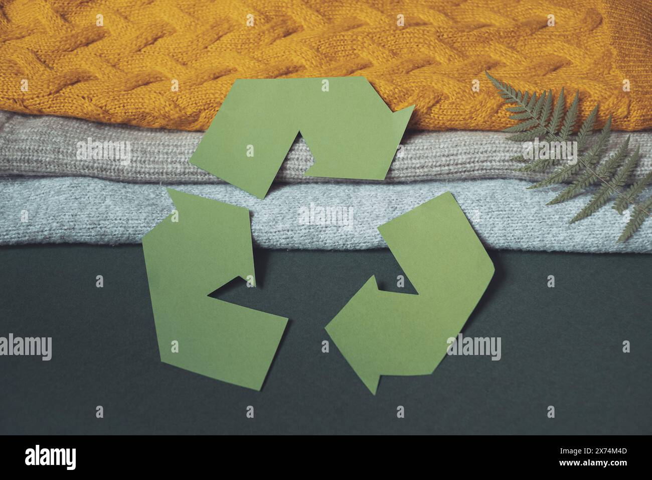 Recycle sign cut out of cardboard on pile of autumn clothes. Recycle ...