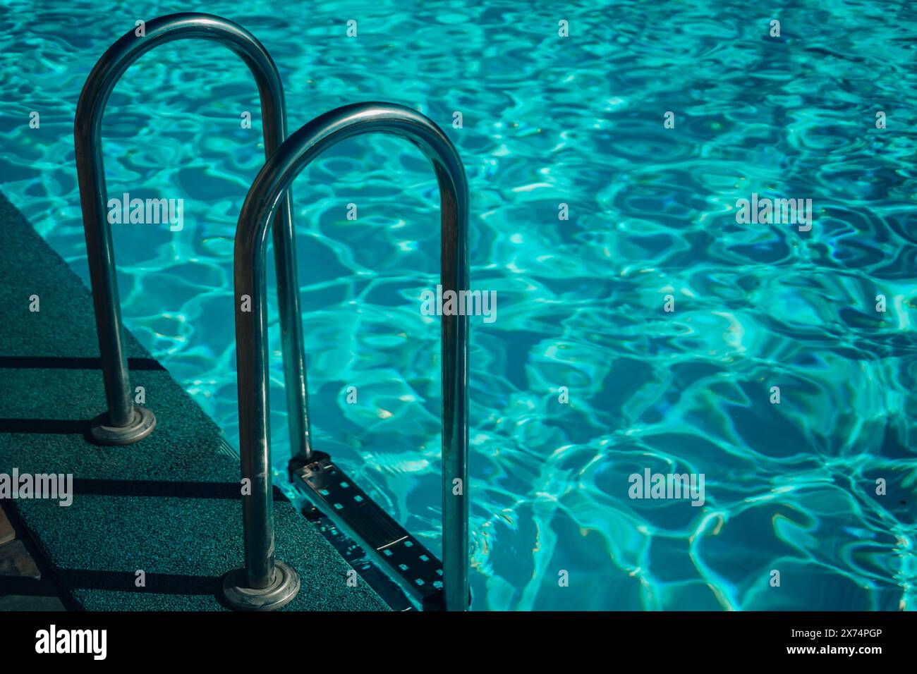 A metal ladder is in the water. The water is clear and calm. The ladder ...