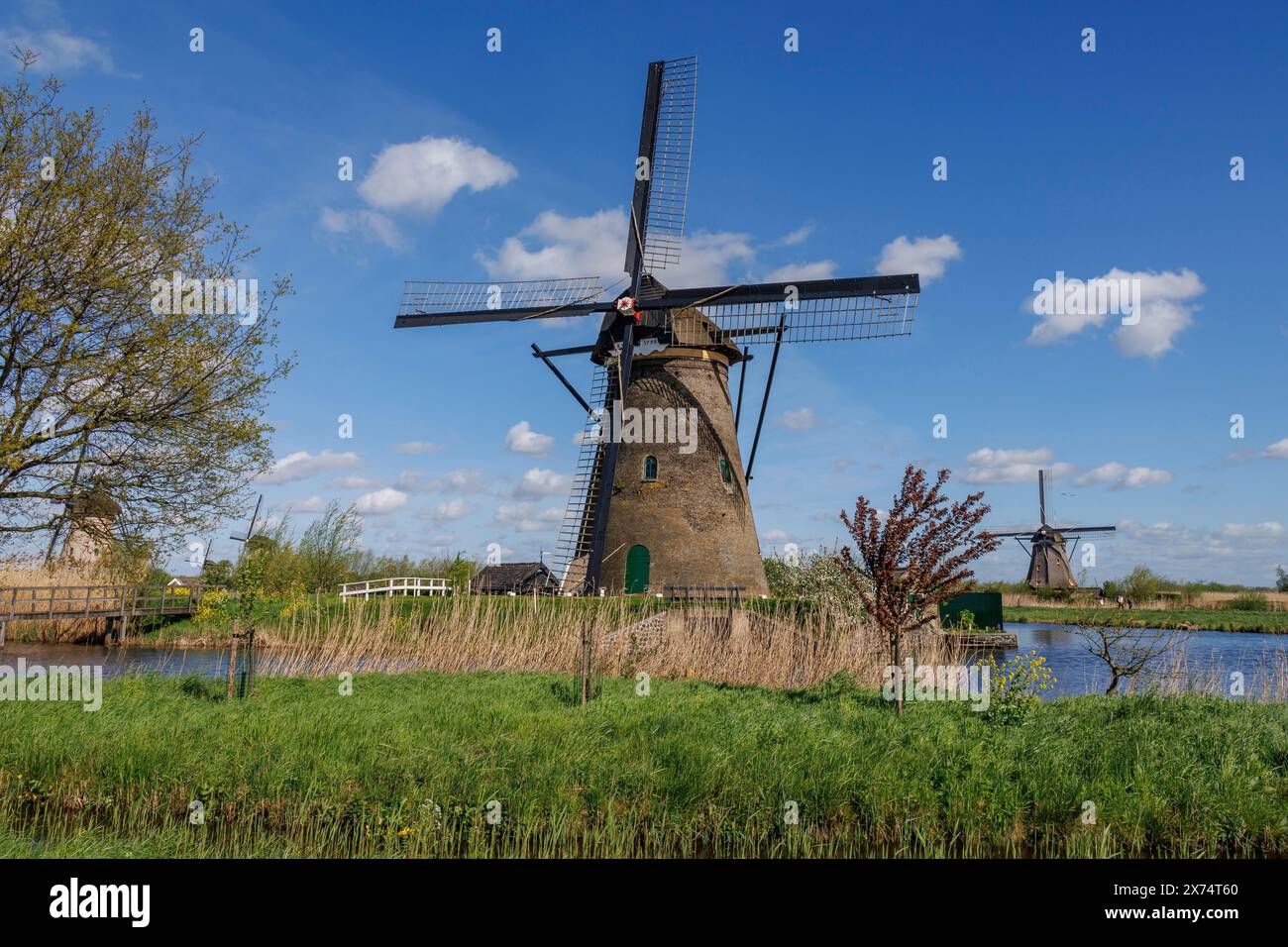 A windmill stands majestically in a natural spring landscape in a clear ...
