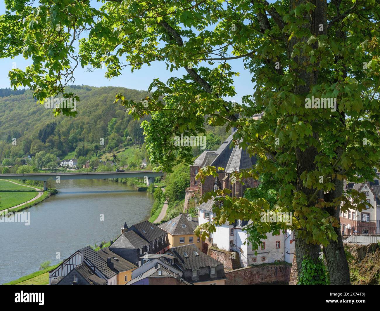 A picturesque riverside village with old houses and dense vegetation ...