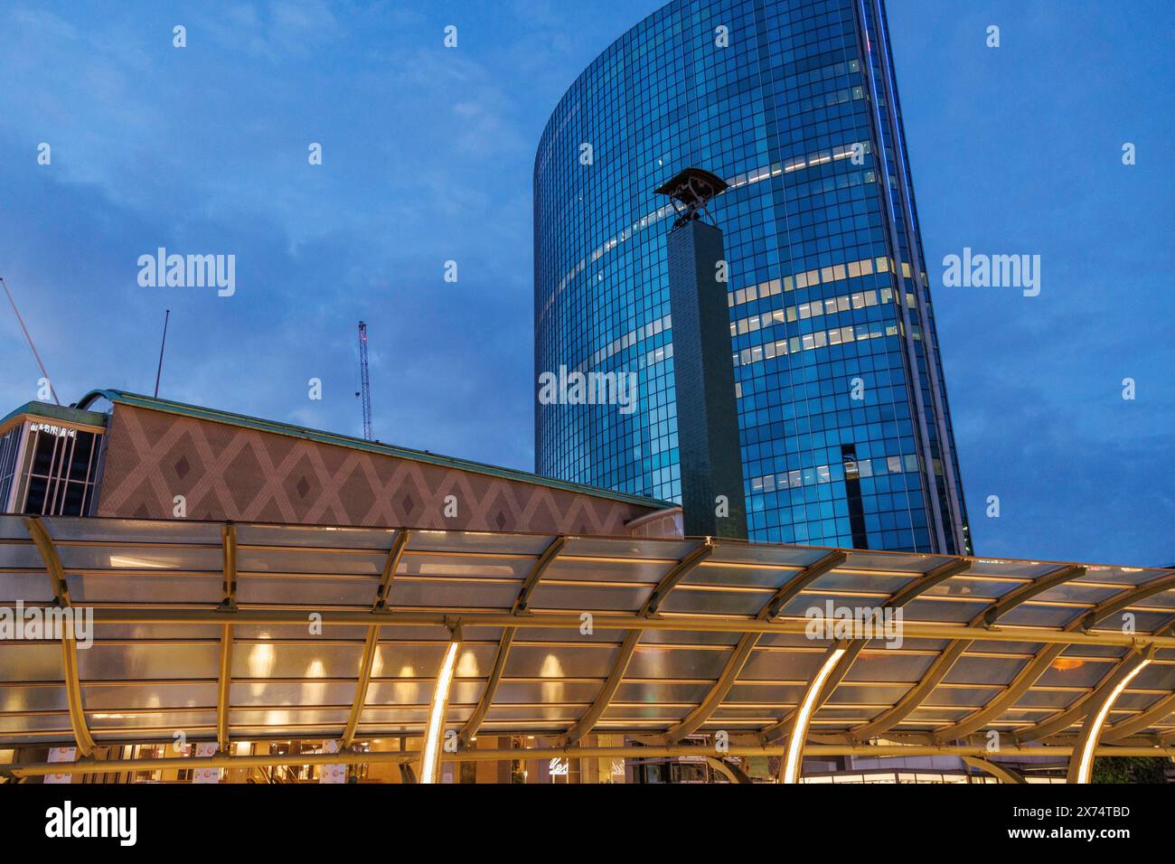 Modern glass building in the city, illuminated at night, small harbour ...