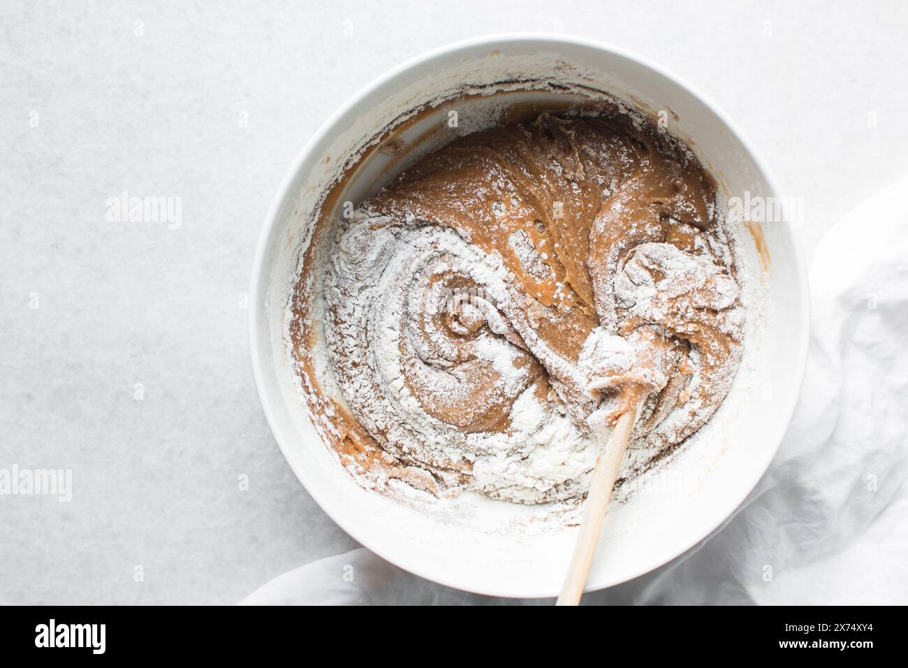 Flour being folded into sugar cookie dough, process of making sugar ...